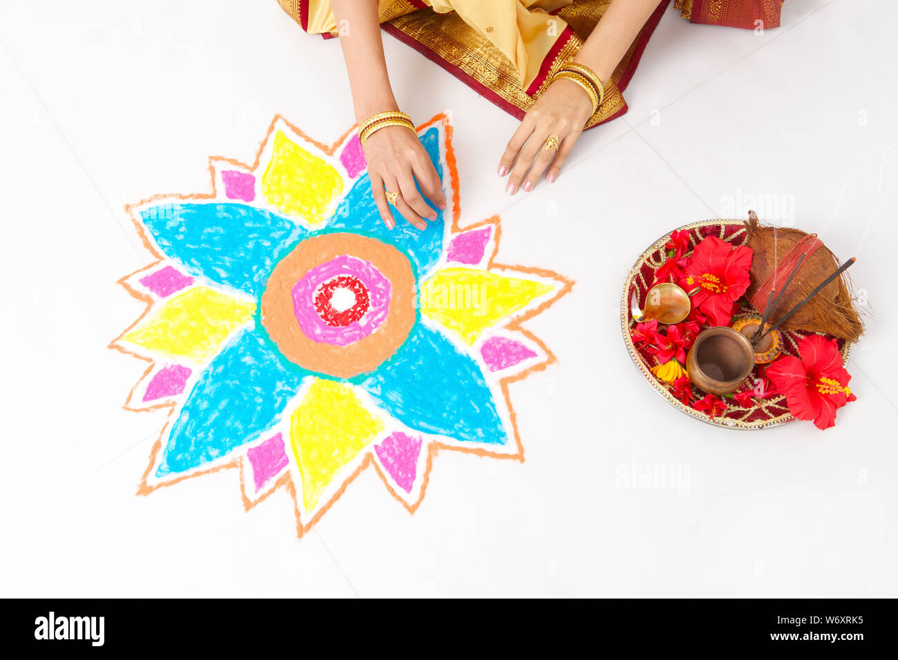 High angle view of a woman making a rangoli Stock Photo - Alamy