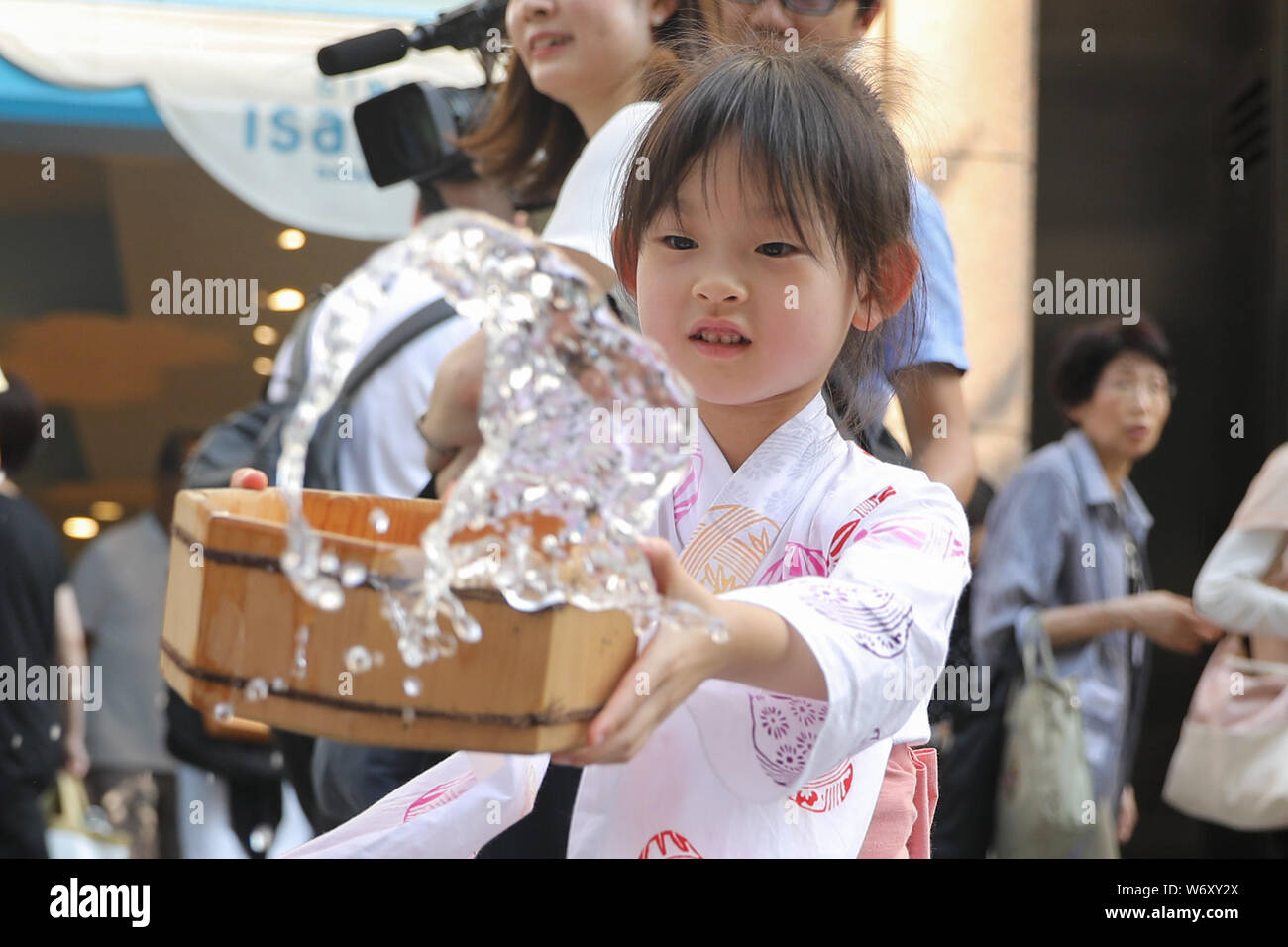 Tokyo, Japan. 3rd Aug, 2019. A girl in traditional costume splashes ...