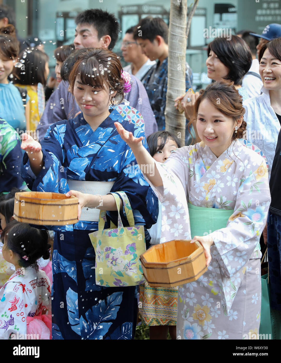 Tokyo, Japan. 3rd Aug, 2019. Two women in traditional costumes splash ...