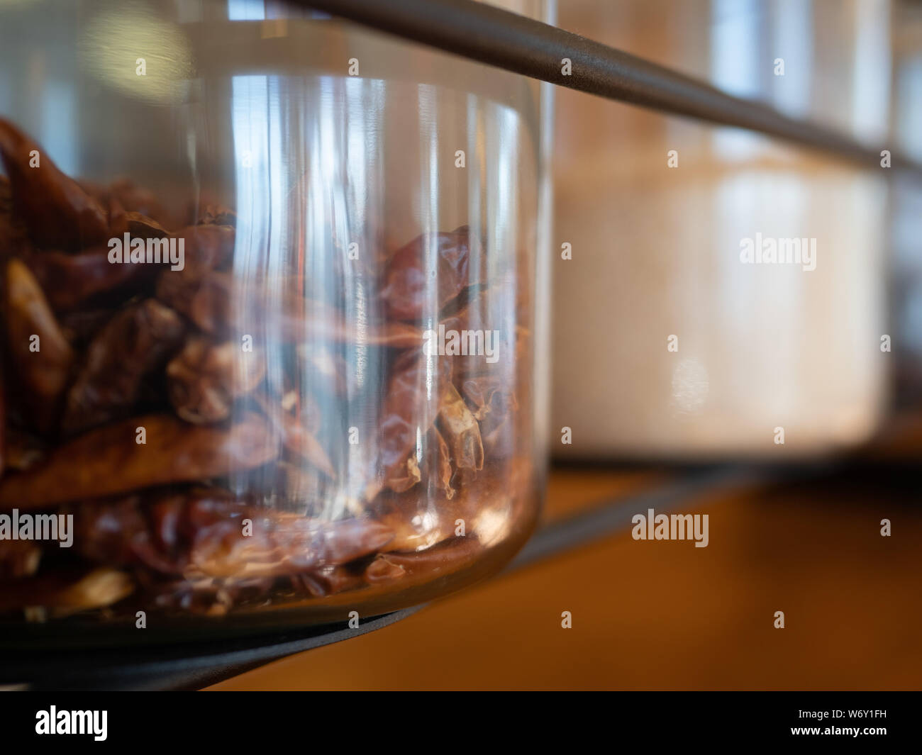 Dried red peppers in jar on display in bright storage room Stock Photo ...