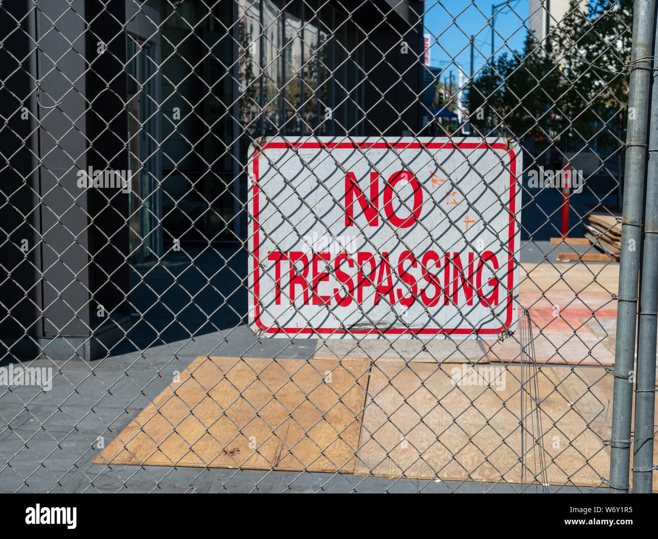 No trespassing sign behind chain link fence blocking off urban ...