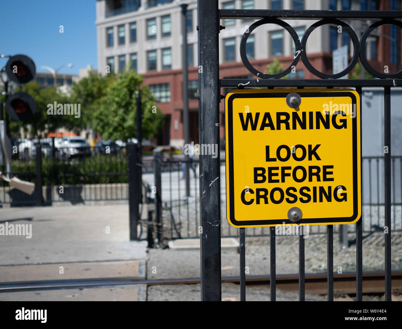 Warning look before crossing yellow warning sign at train crossing in ...