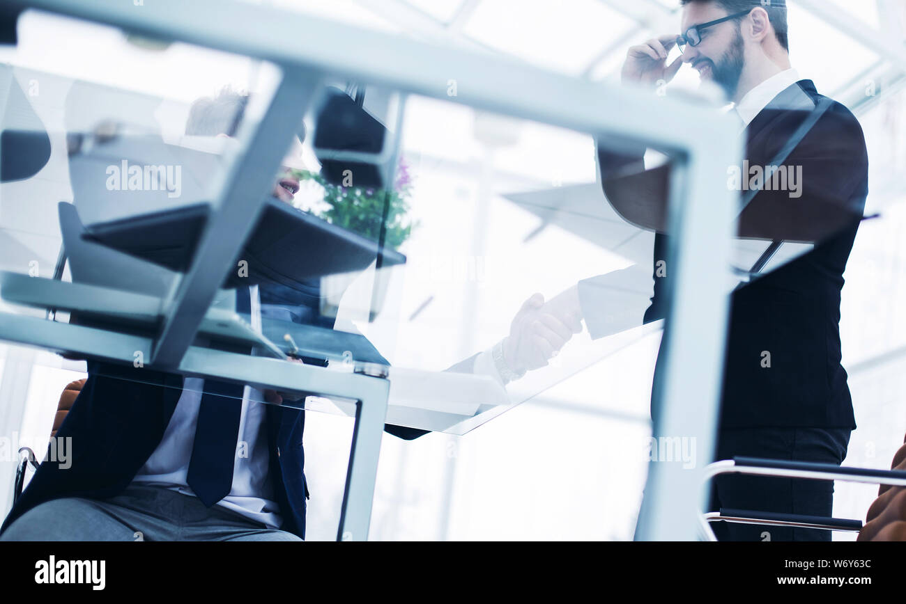 handshake of employees in the workplace in a modern office.the photo ...