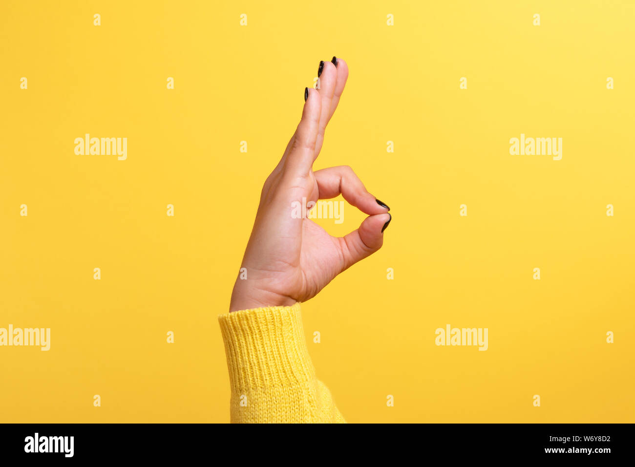 hand ok sign over trend yellow background Stock Photo - Alamy