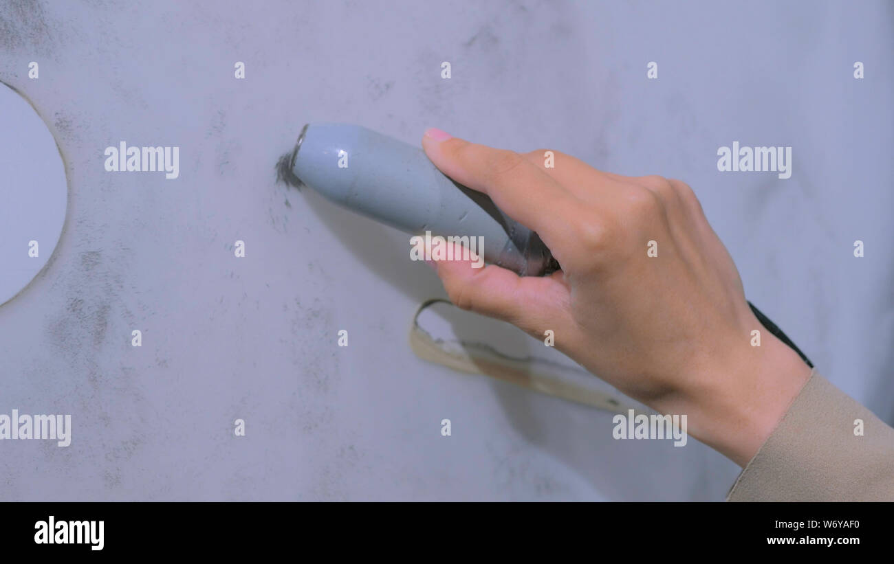 Woman with magnet stick controls ironsand particles Stock Photo - Alamy