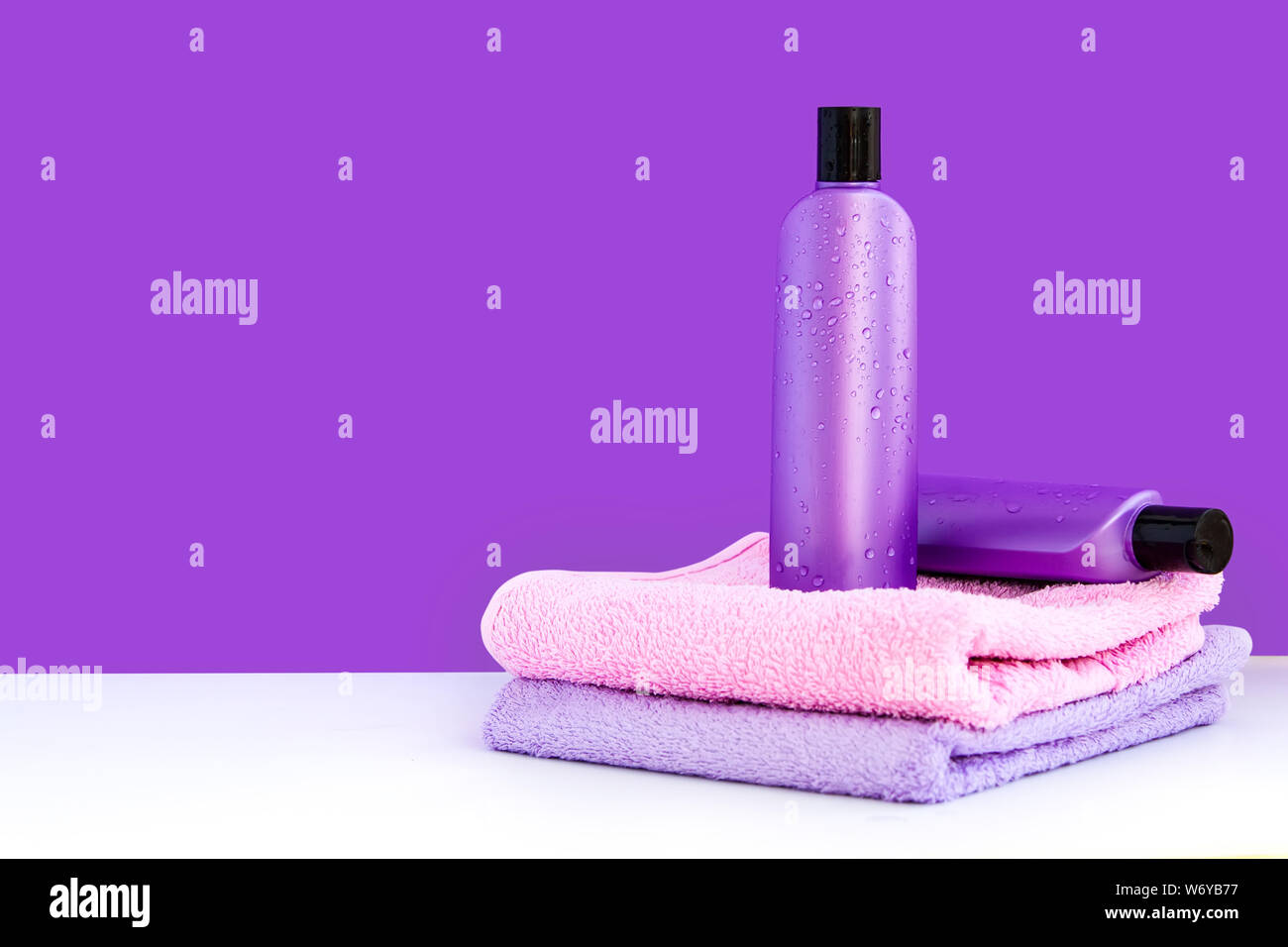 two purple cosmetic bottles on two bath towels for Spa treatments and ...