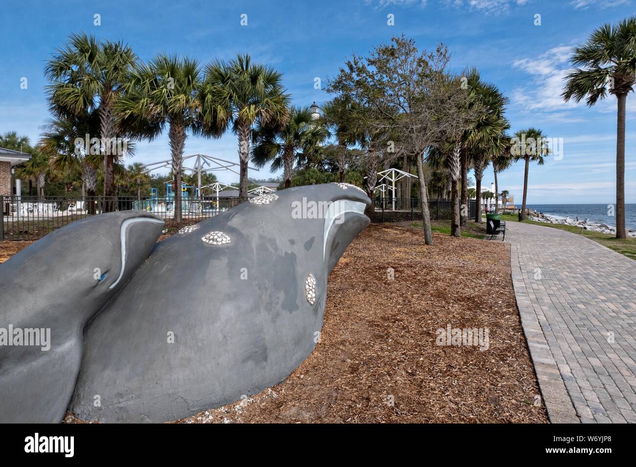 A whale sculpture in Neptune park with the St. Simons Lighthouse behind ...