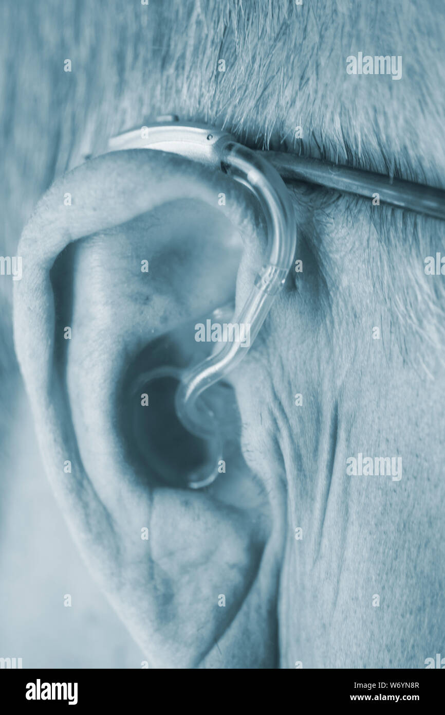 Caucasian white old aged man wearing modern digital hearing aid in ear ...