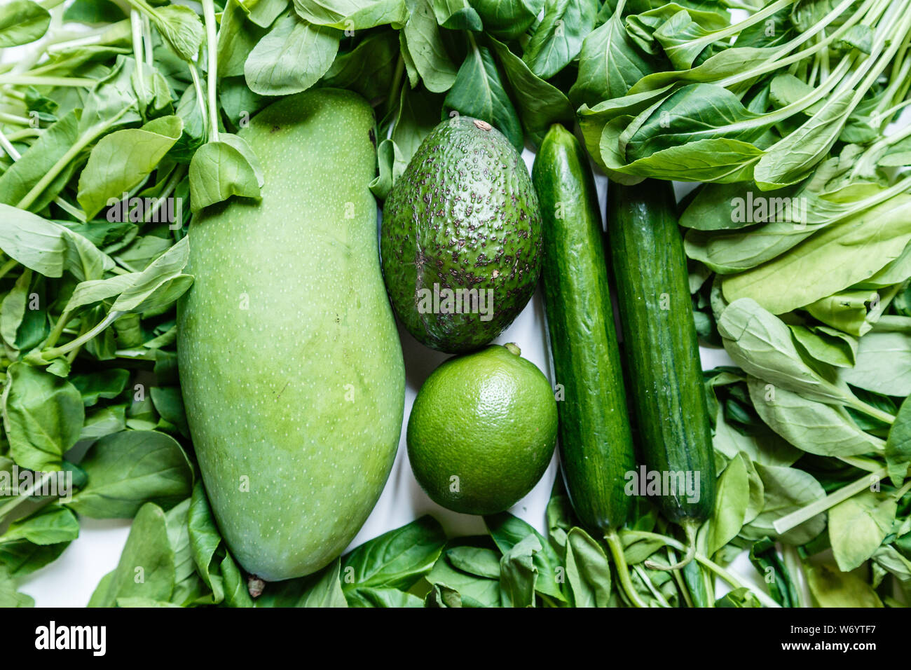Fresh green vegetables variety on rustic white background from overhead ...