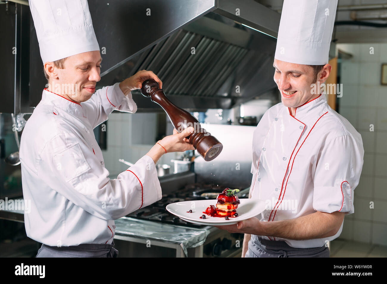 Two Chefs Sha background kitchen pepper dishes Stock Photo - Alamy
