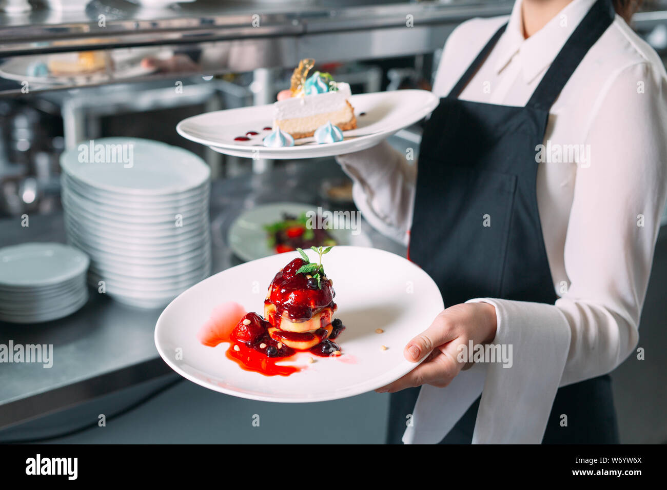Waiter serving in motion on duty in restaurant. The waiter carries ...