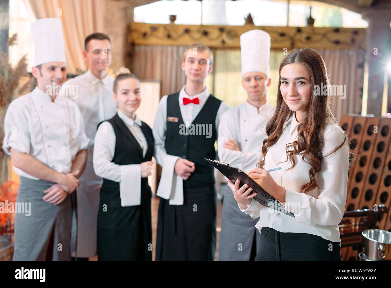 restaurant manager and his staff in kitchen. interacting to head chef ...