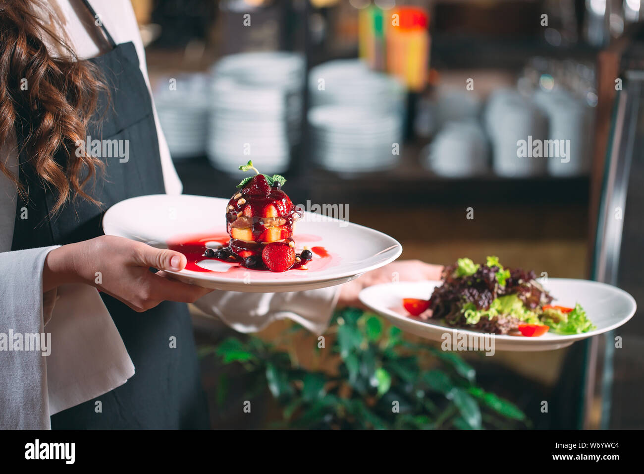 Waiter serving in motion on duty in restaurant. The waiter carries ...