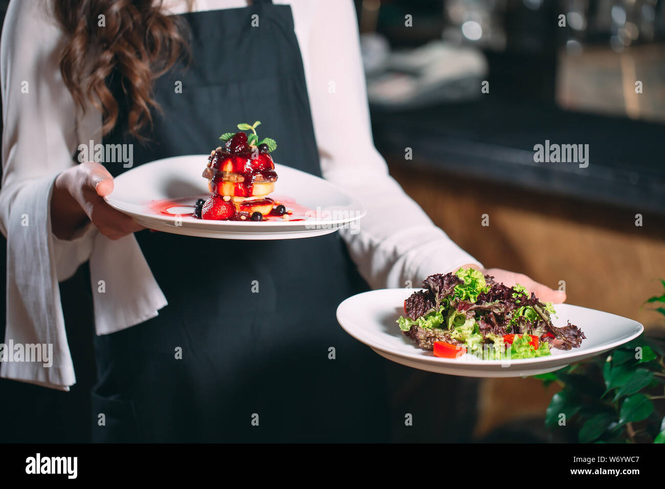 Waiter serving in motion on duty in restaurant. The waiter carries ...