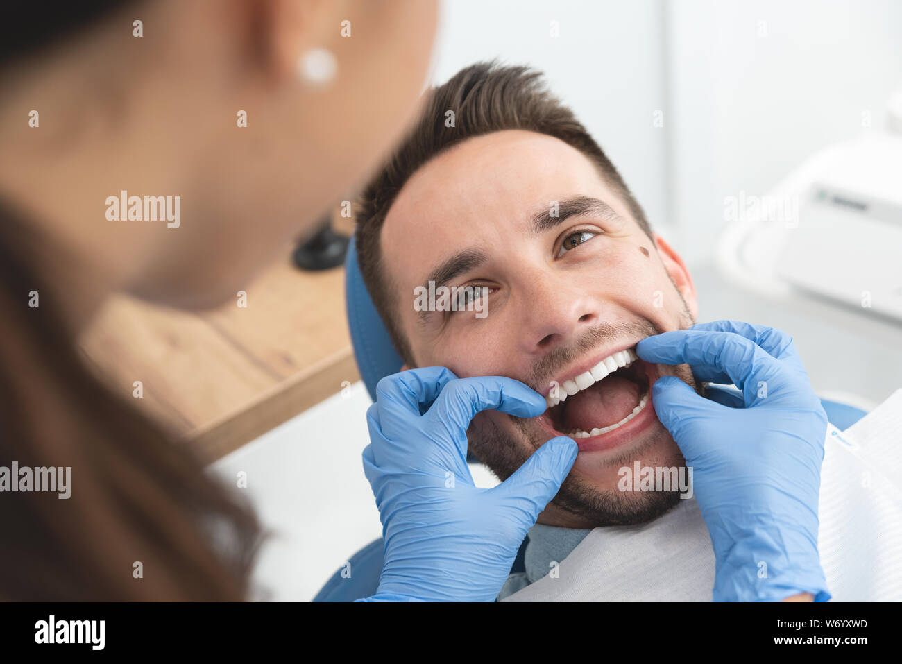 Man having a visit at the dentist's. Handsome patient sitting on chair ...