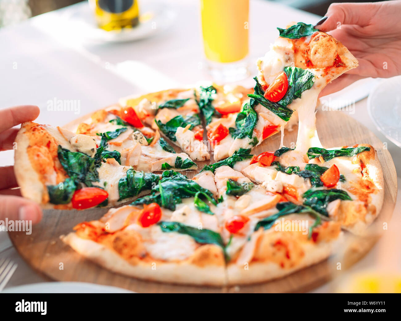 Eating Pizza. Hands close-up take pieces of pizza Stock Photo - Alamy
