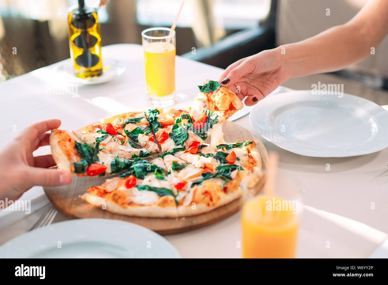Eating Pizza. Hands close-up take pieces of pizza Stock Photo - Alamy