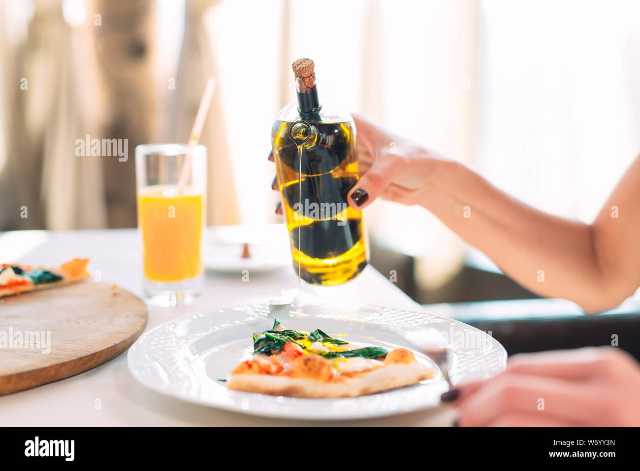 The girl pours oil a tasty Pizza Stock Photo - Alamy