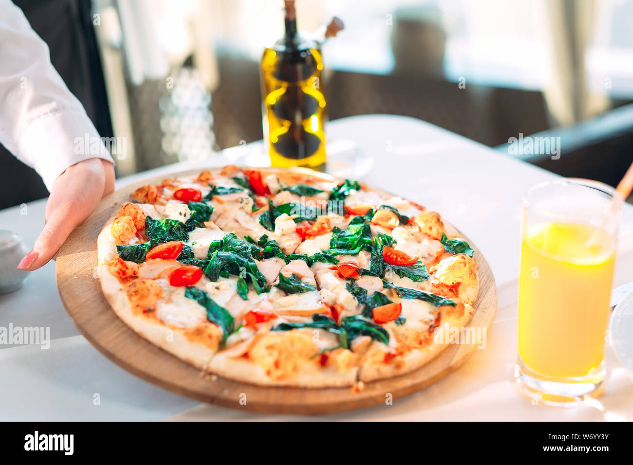 The waiter puts pizza On the table in the Restaurant Stock Photo - Alamy
