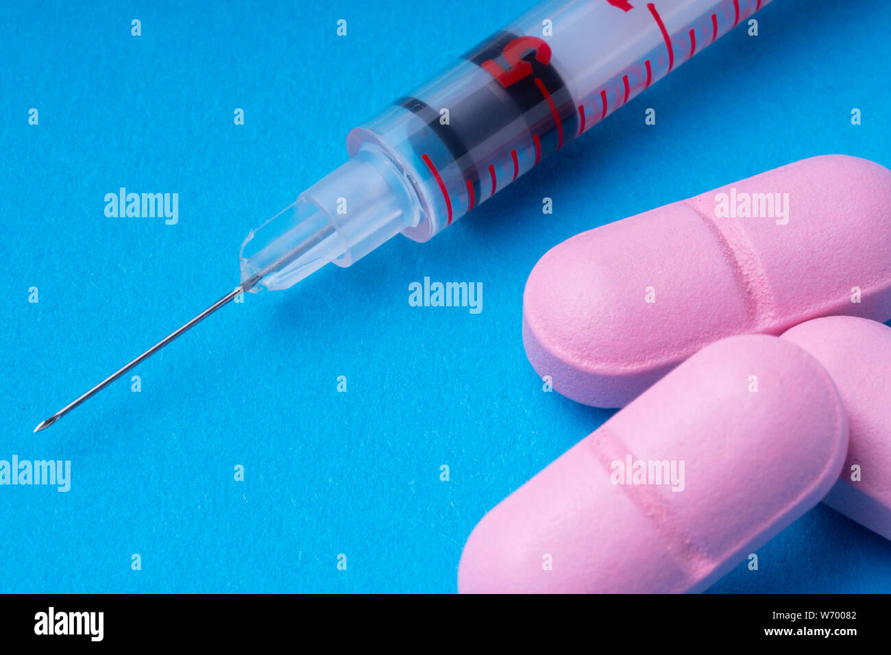 1ml insulin syringes and pink pills on a blue background. omega3 Stock ...