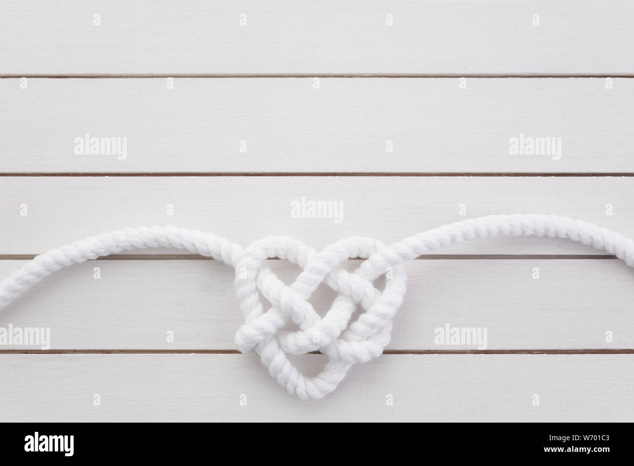 Heart shaped knot on white wooden background Stock Photo - Alamy