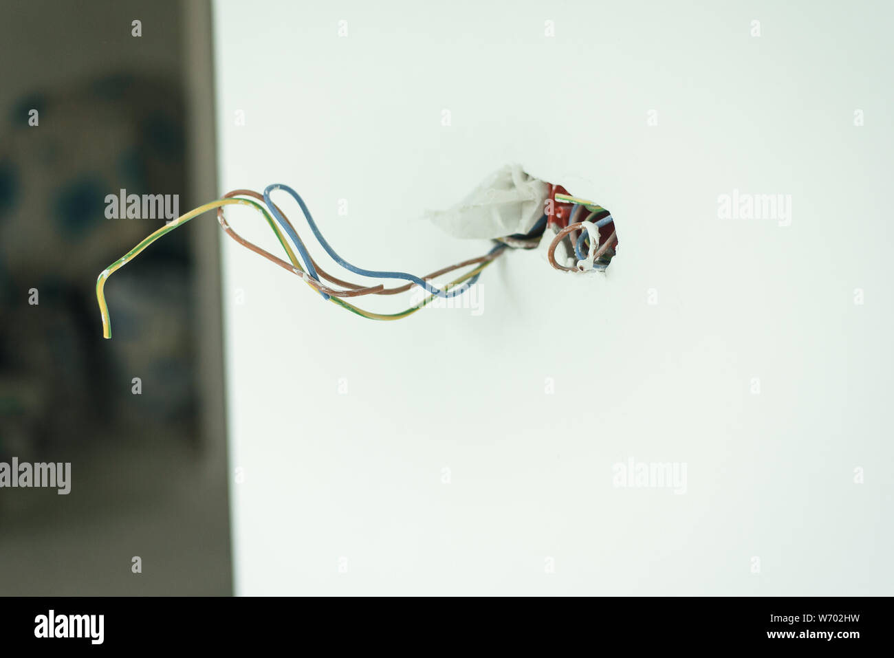 protruding wires from the outlet. Unfinished home repair on a white ...