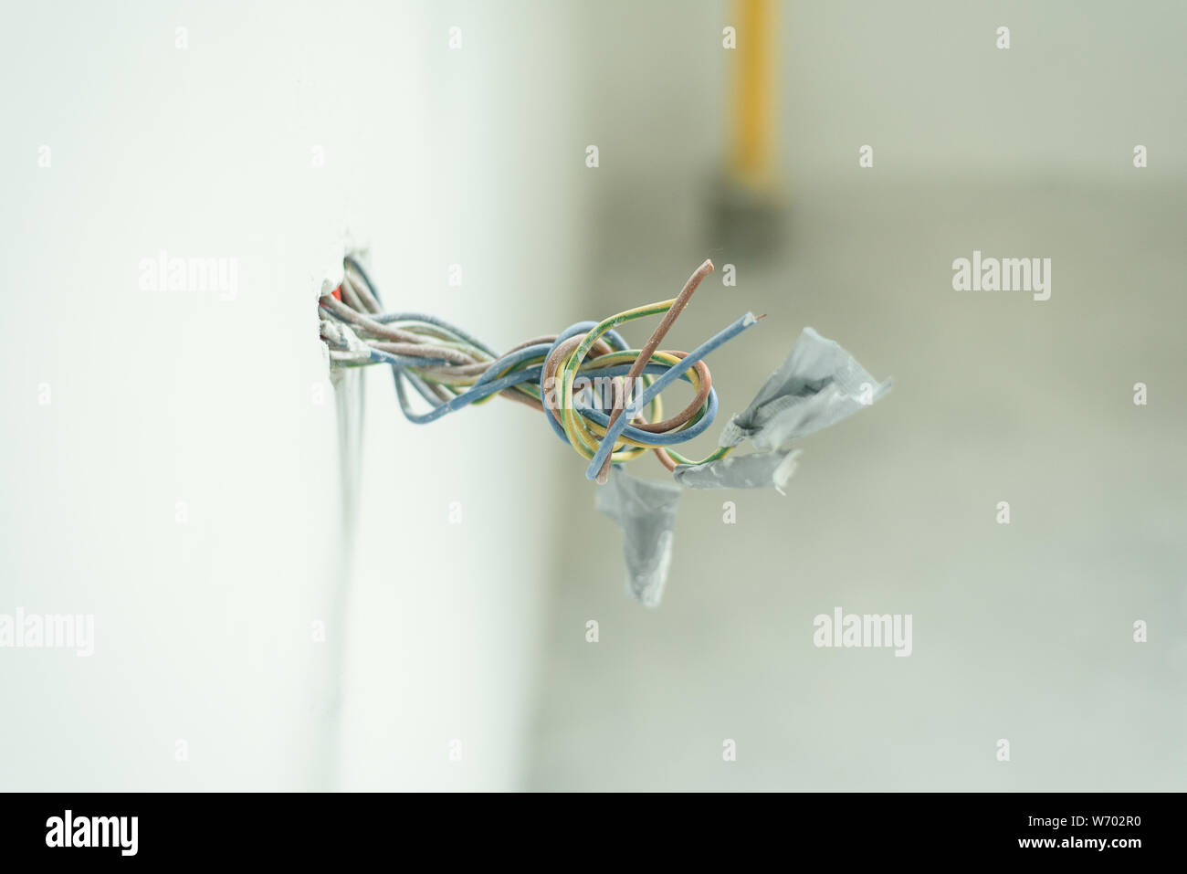 protruding wires from the outlet. Unfinished home repair on a white ...