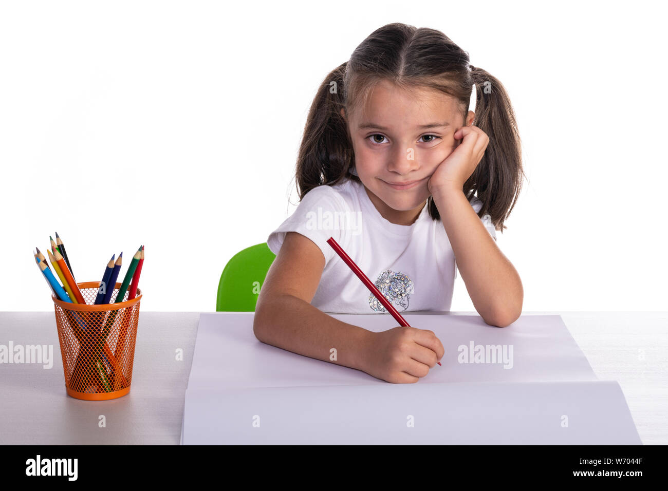 Girl starting to draw on blank paper with multi colored pencils on ...