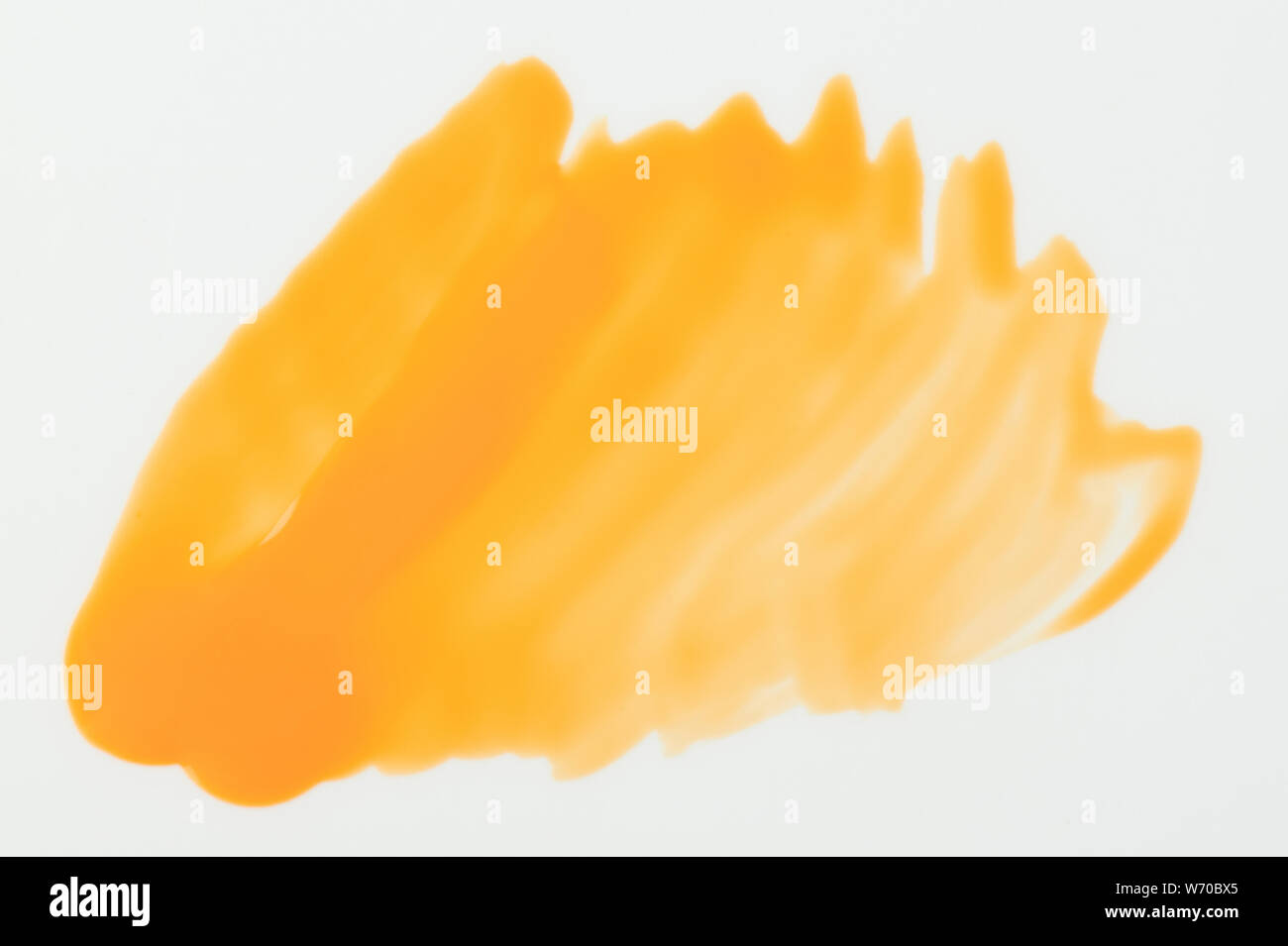 Glossy yellow paint stain isolated on white background close up view ...