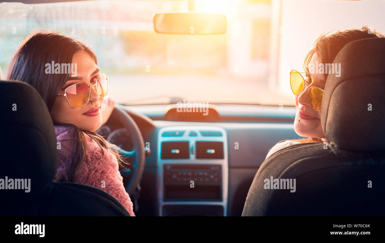 Two young women friends in car looking back Stock Photo - Alamy
