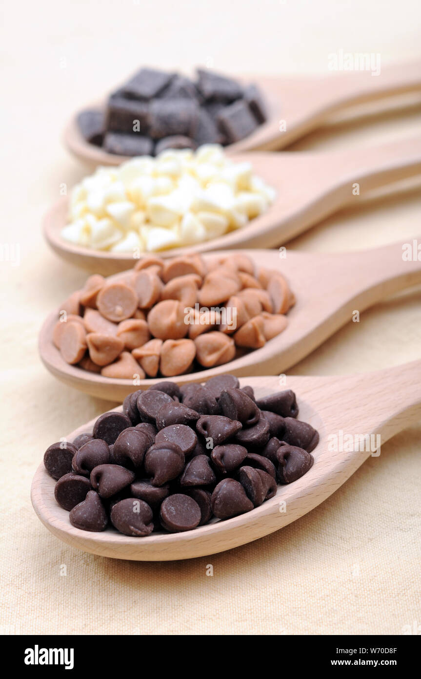 four kinds of chocolate chips in wooden spoons Stock Photo - Alamy
