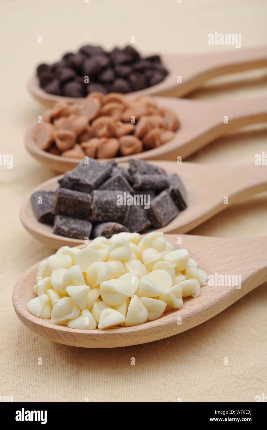four kinds of chocolate chips in wooden spoons Stock Photo - Alamy