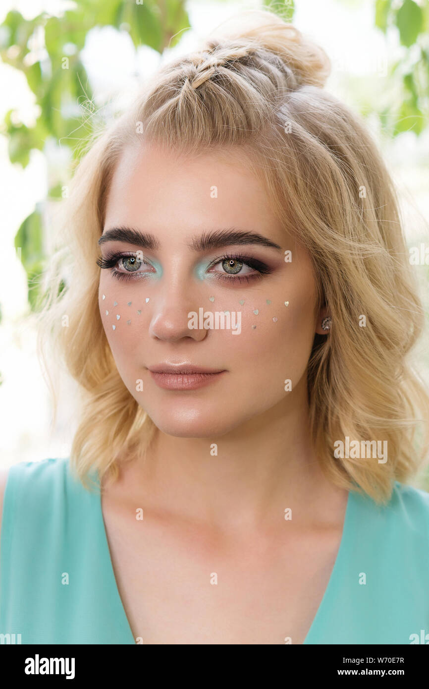 Portrait of cute girl with glitter on cheeks. Attractive charming woman ...