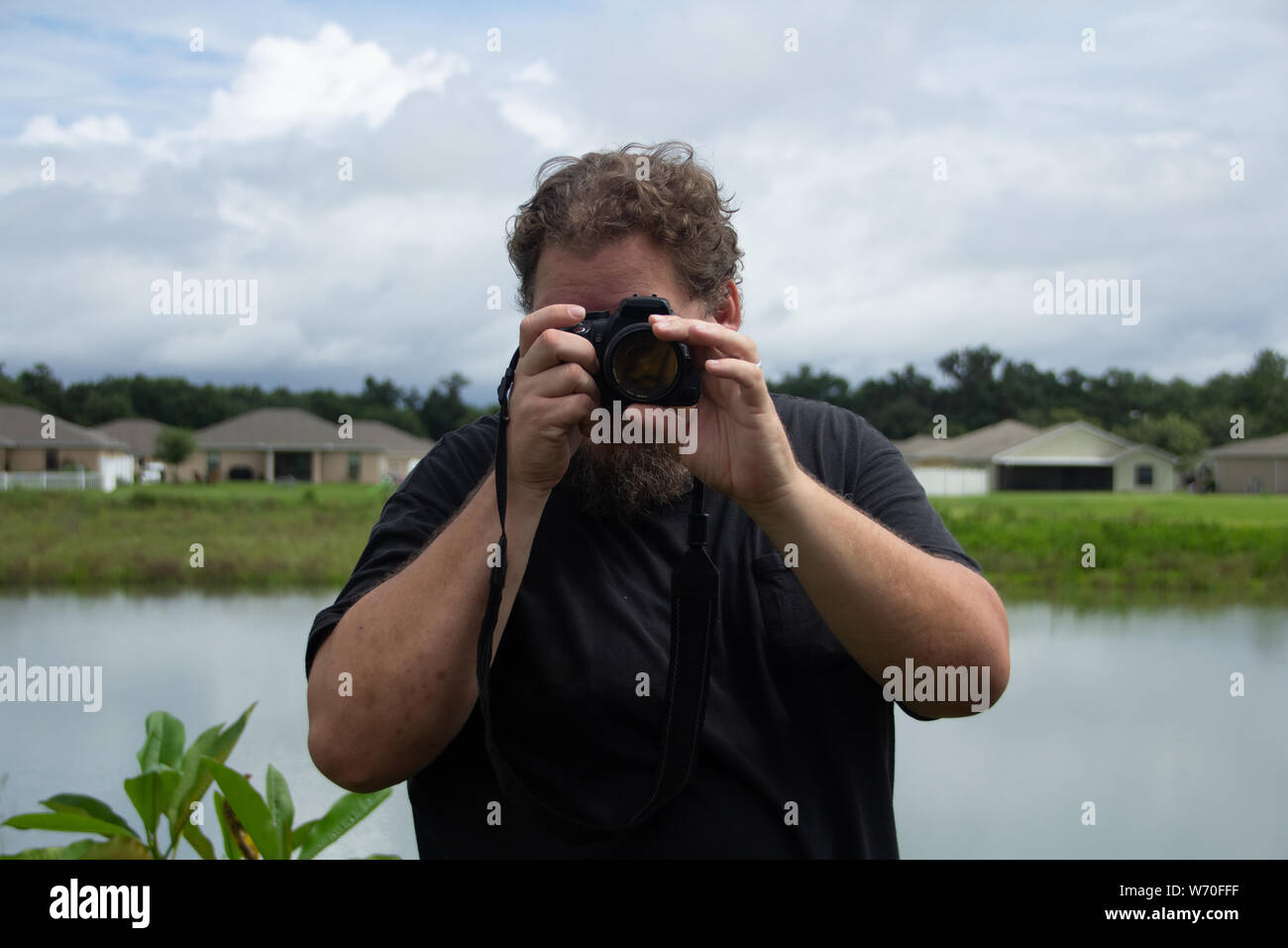 Man taking picture with camera Stock Photo - Alamy