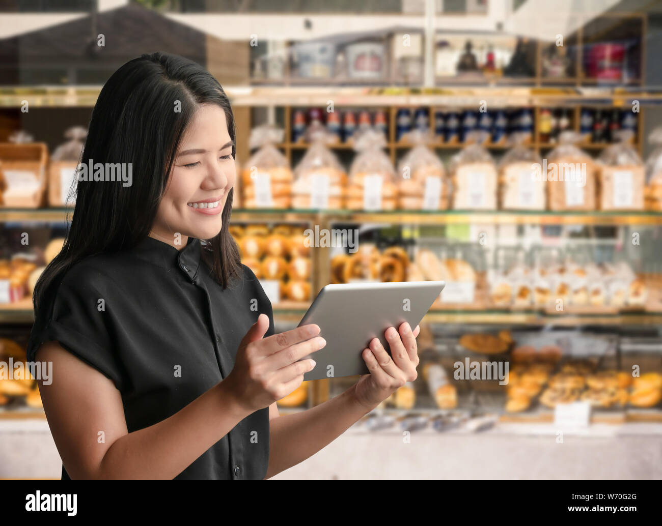 Asian entrepreneur or business owner happy work with digital tablet on ...