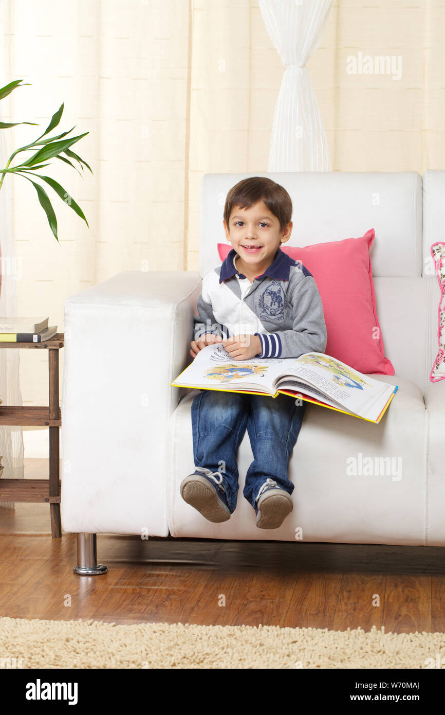 Boy reading a book at home Stock Photo - Alamy