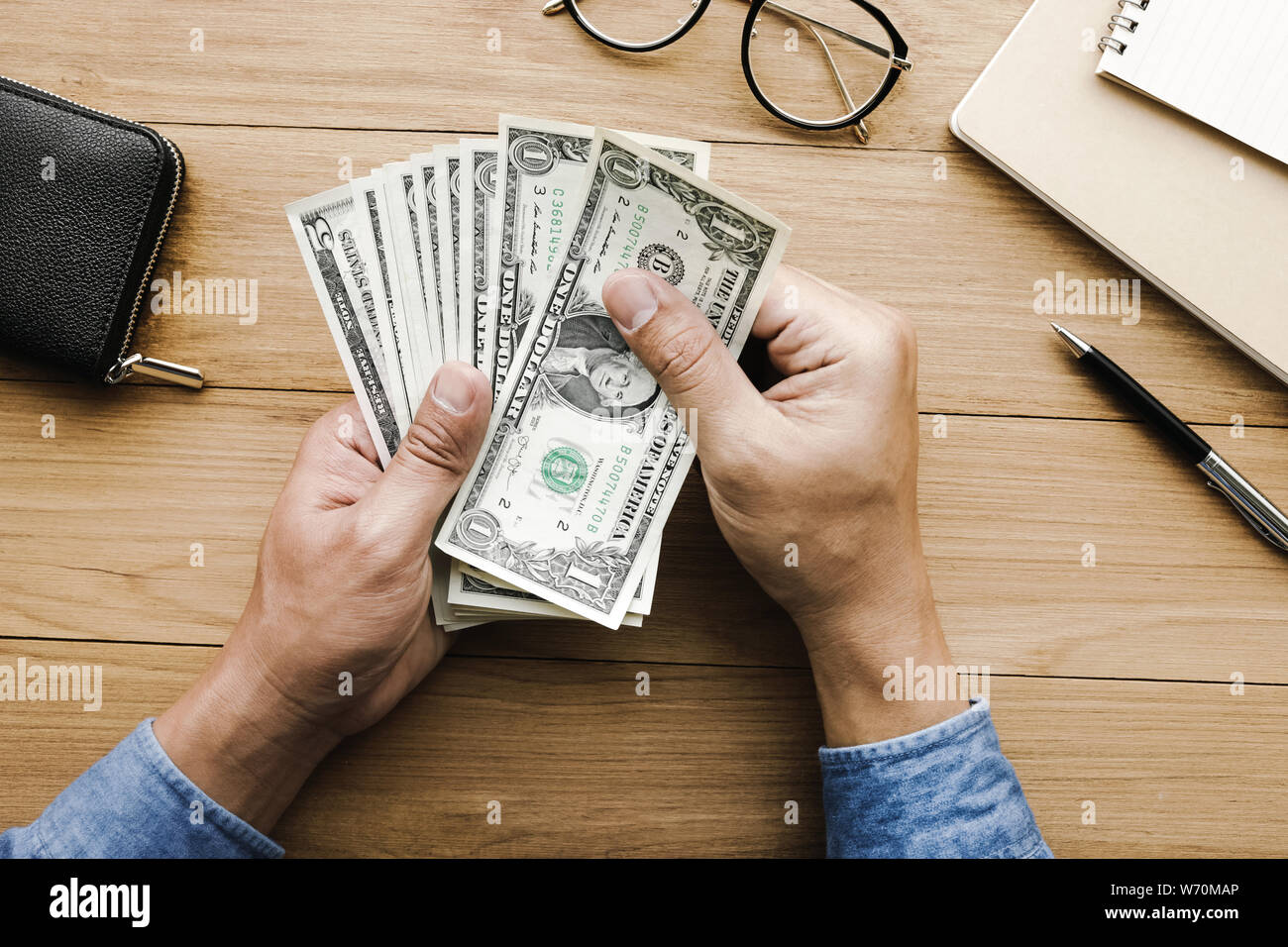 Male hand holing money dollar bill.on wood table.business investment ...