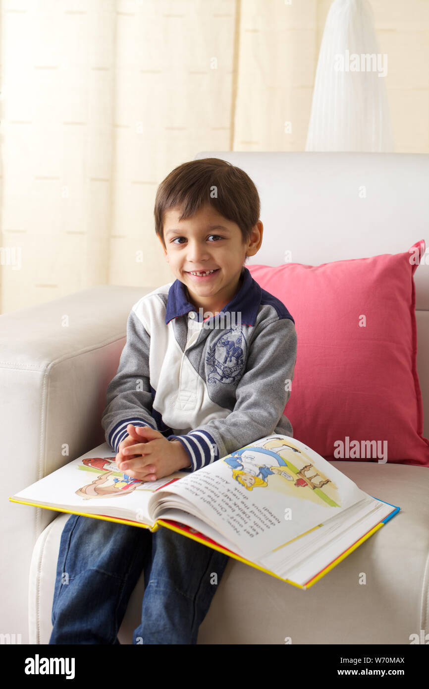 Boy reading a book at home Stock Photo - Alamy