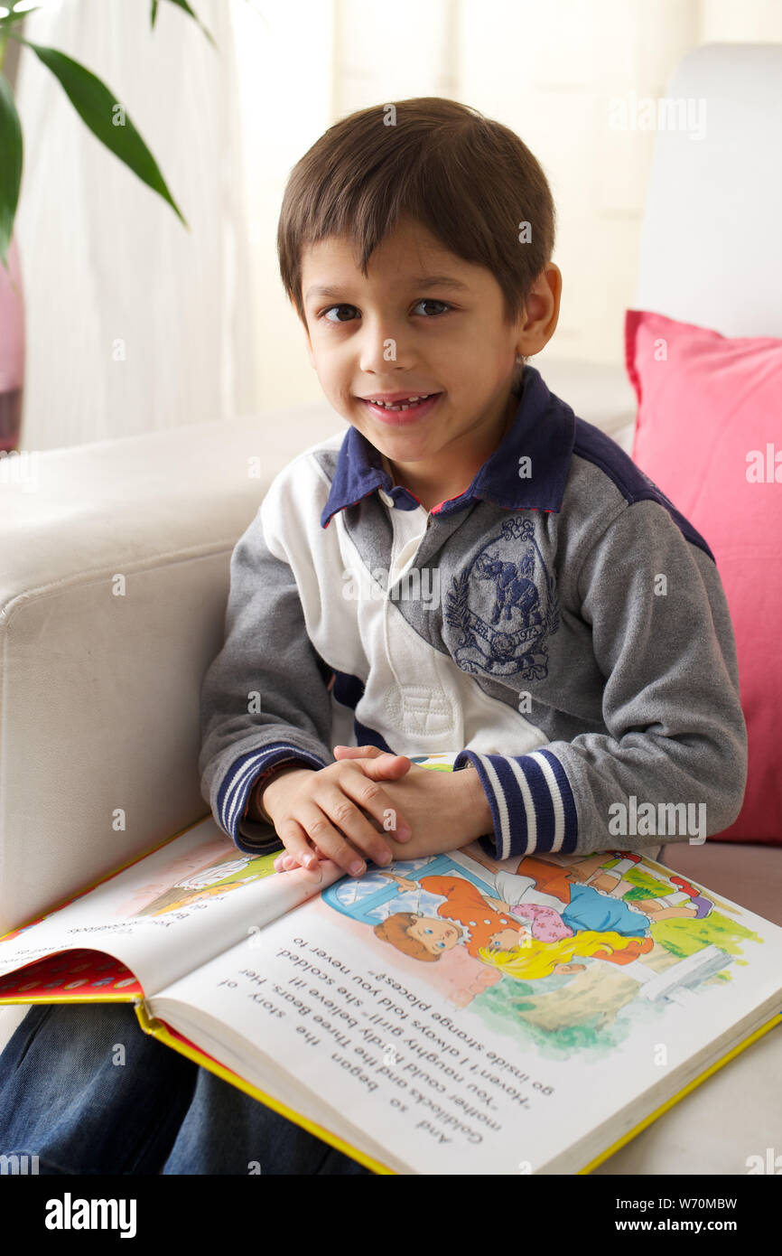 Boy reading a book at home Stock Photo - Alamy