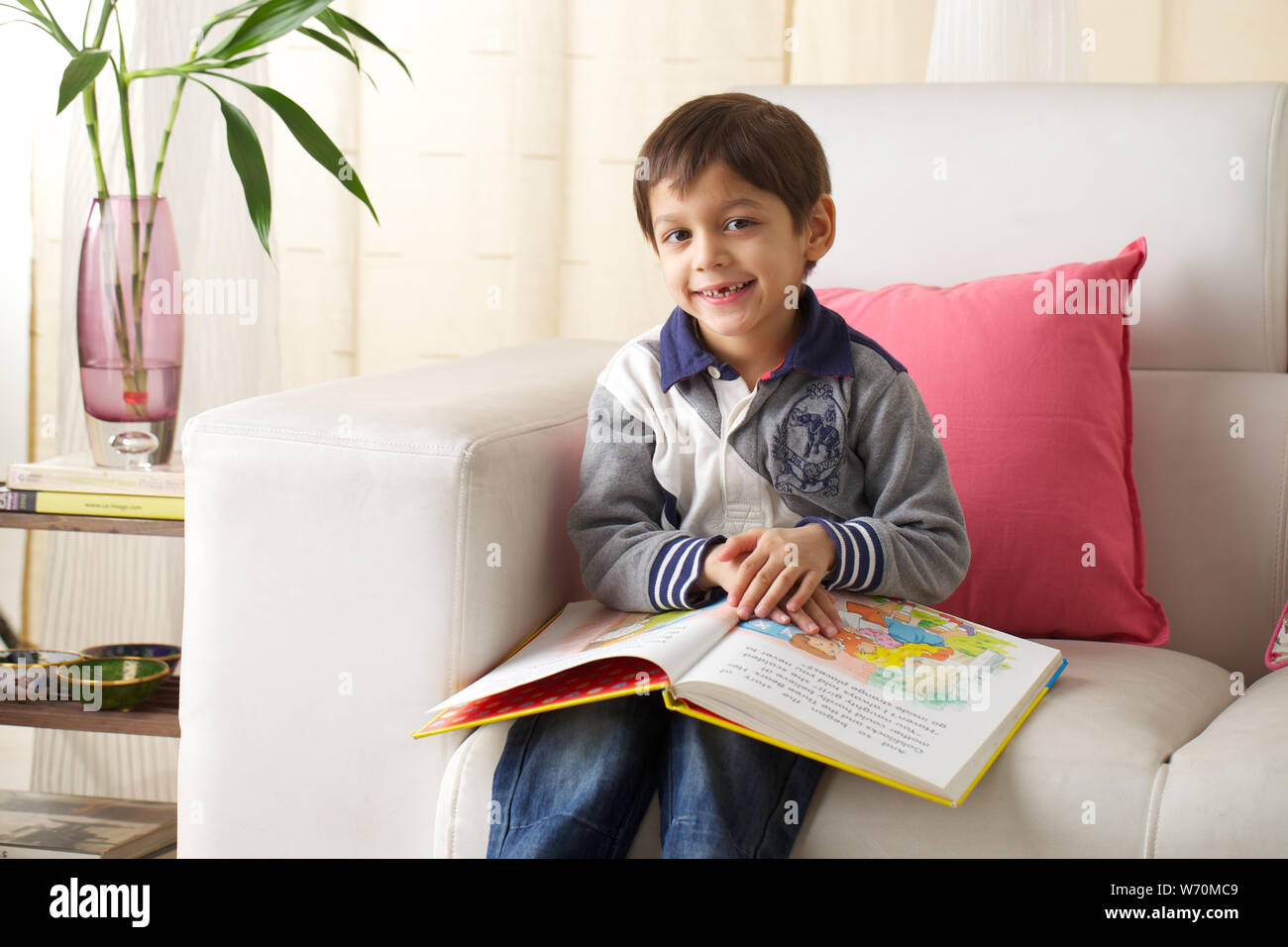 Boy reading a book at home Stock Photo - Alamy