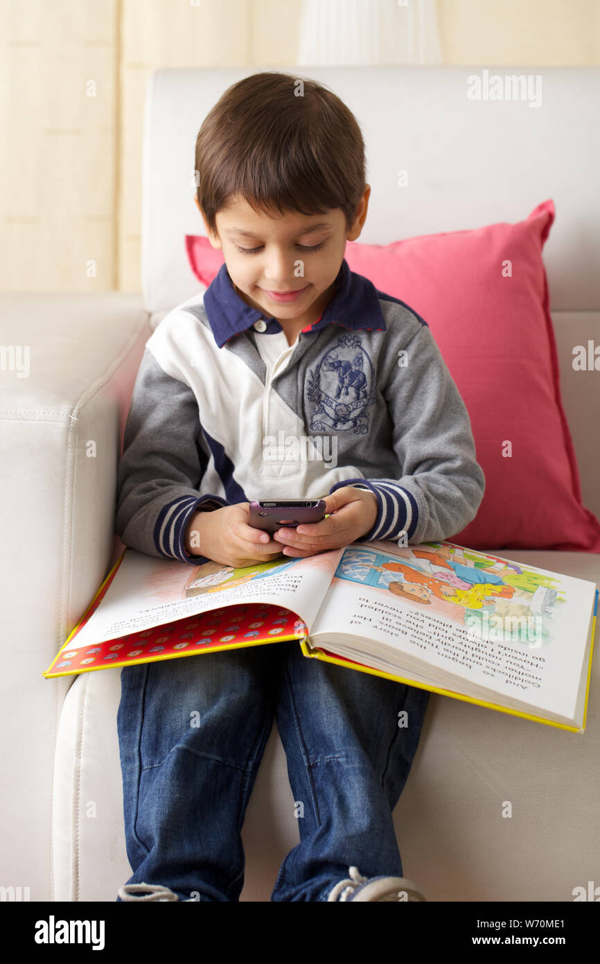 Boy text messaging on mobile phone Stock Photo - Alamy