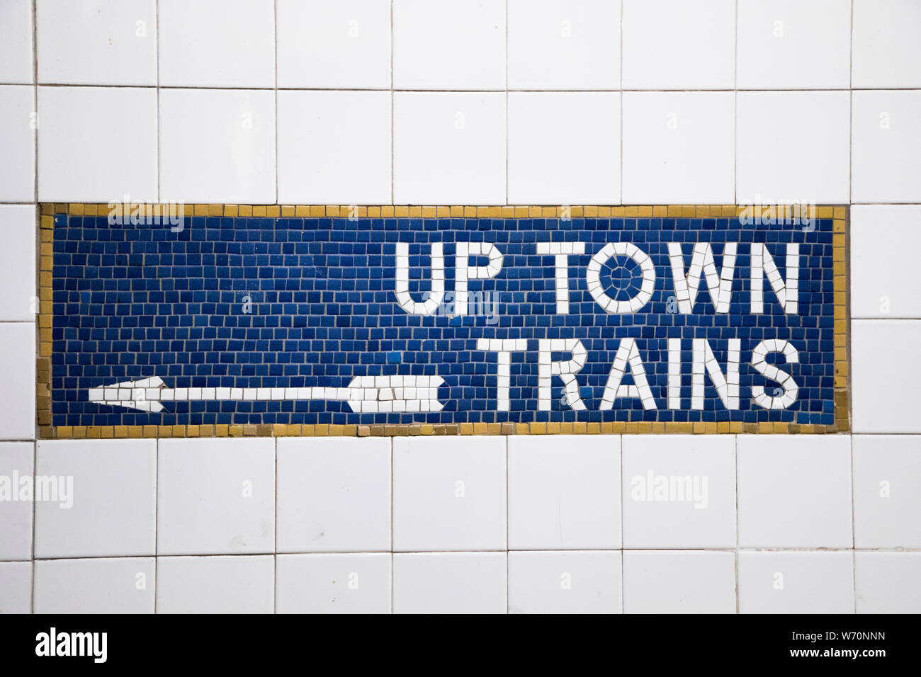 New York subway white tile wall with blue tiled Uptown Trains sign ...