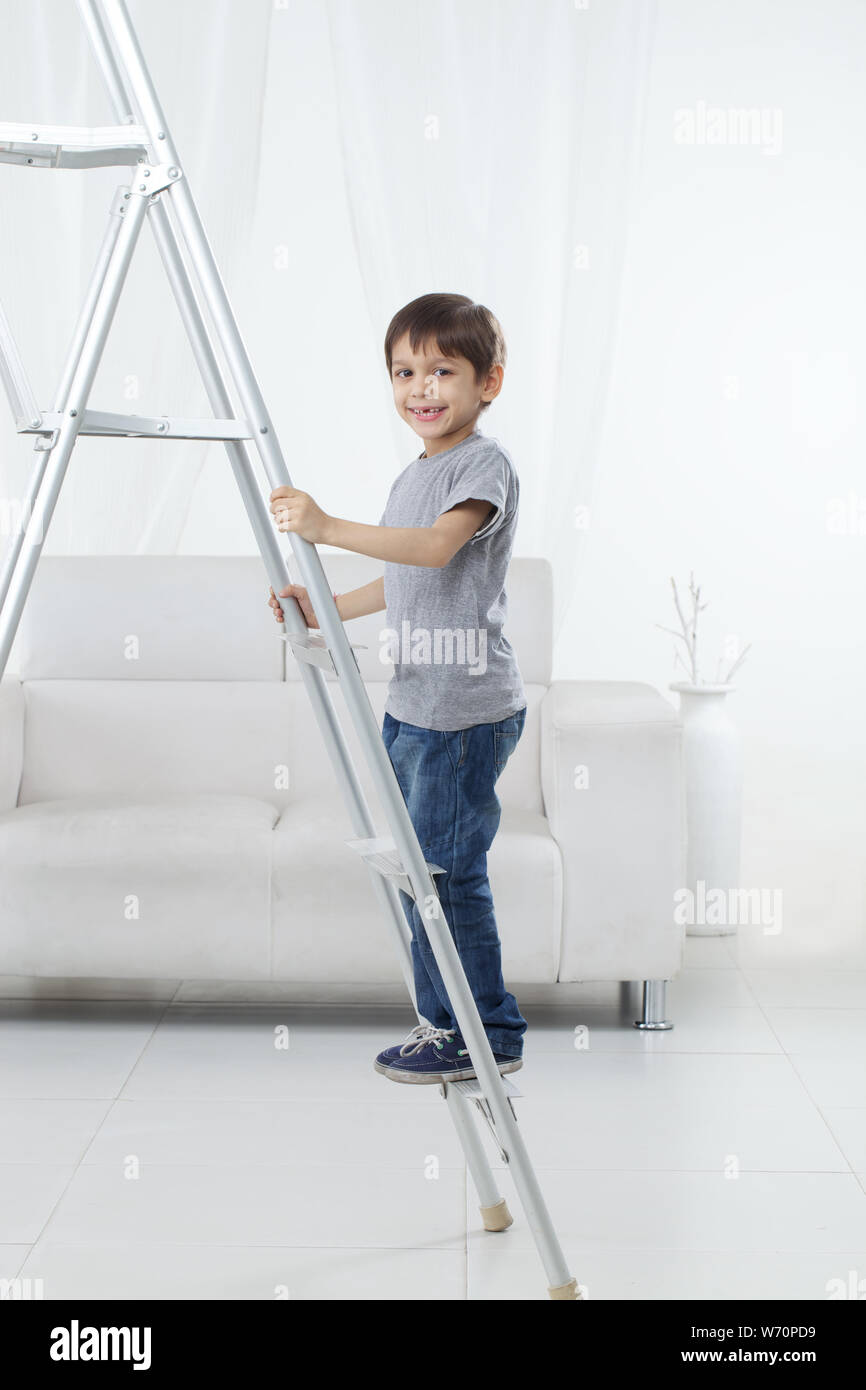 Boy climbing a step ladder and smiling Stock Photo - Alamy