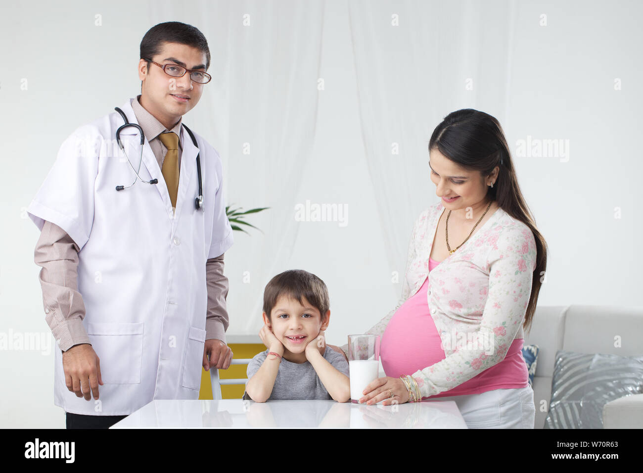 Pregnant mother with her son with a doctor at home Stock Photo - Alamy
