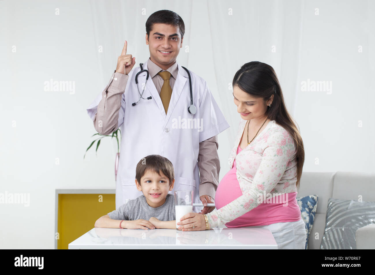 Pregnant mother with her son with a doctor at home Stock Photo - Alamy