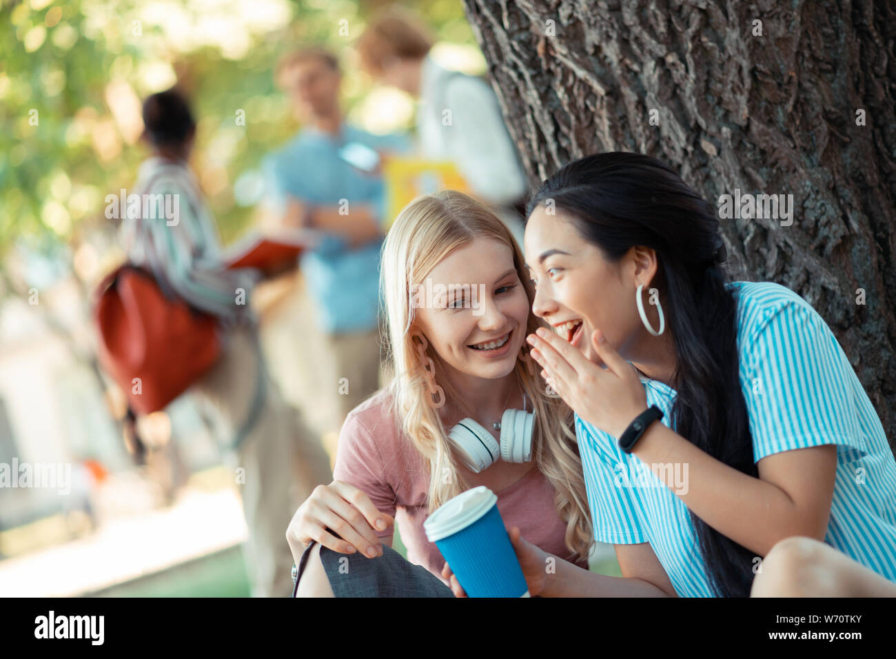 Two gossip girls talking about their friends Stock Photo - Alamy