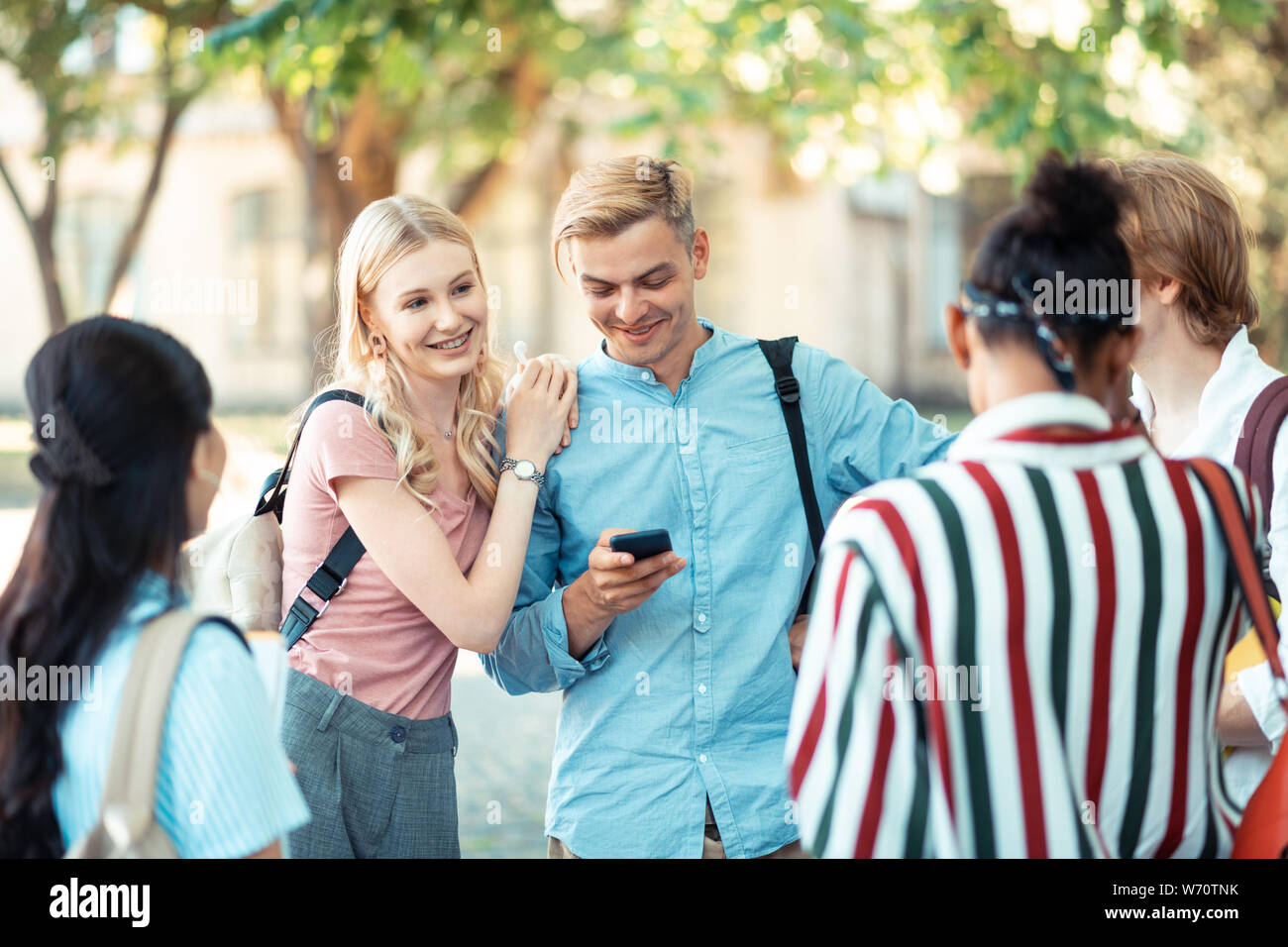Student couple communicating with their groupmates outside Stock Photo ...