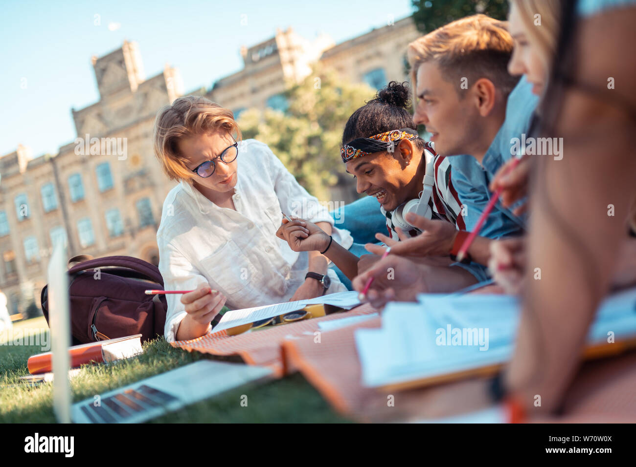 Concentrated boy doing difficult task near his groupmates Stock Photo ...
