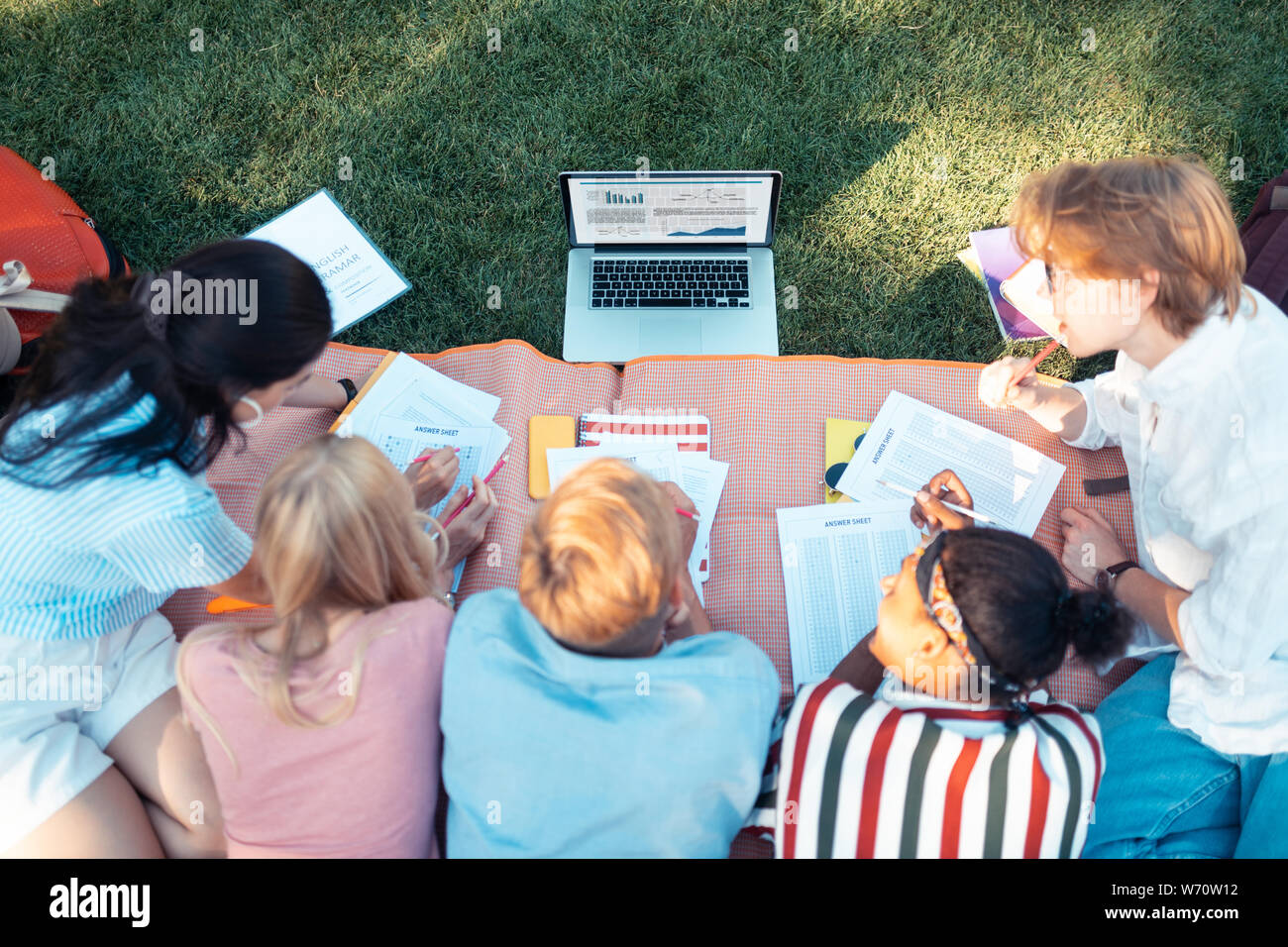Group of students solving problems from the laptop Stock Photo - Alamy