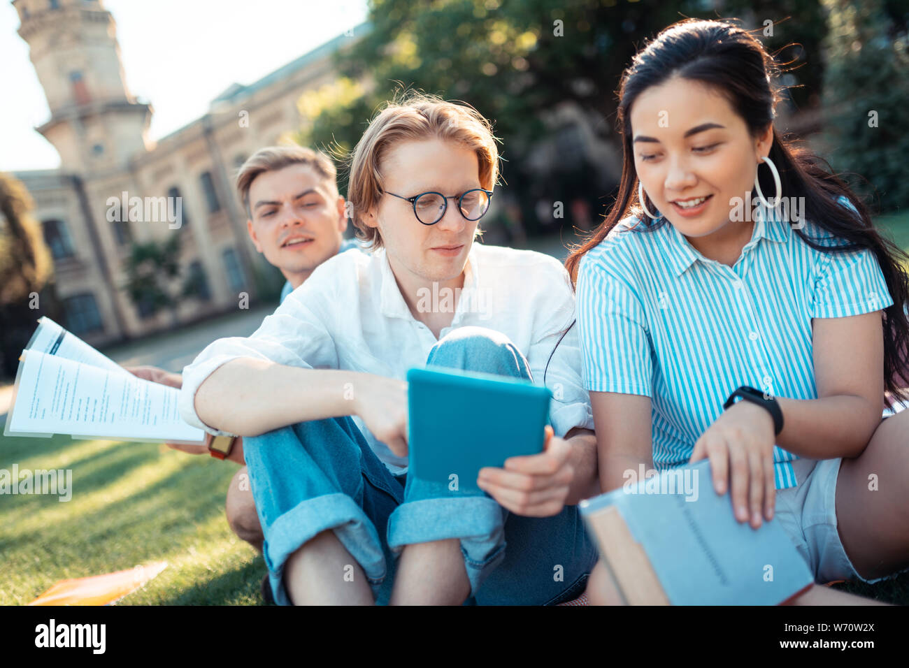 Smiling boy showing a task to his groupmate Stock Photo - Alamy